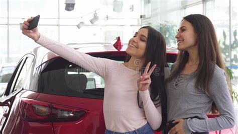 Cheerful Female Friends Taking Selfies Near The New Car Stock Image