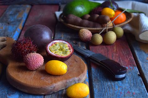 열정 과일 금 귤 열매 람 부탄 타마린드 아보카도 코코넛 나무 배경에 드래곤 아이와 잘 익은 열 대 과일의 혼합