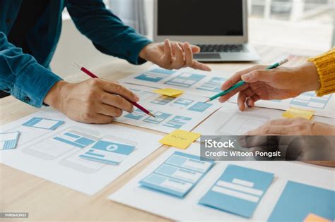 ux 개발자와 ui 디자이너가 현대 사무실에서 고객 요약 및 색상 코드와 함께 테이블에 모바일 앱 인터페이스 와이어프레임