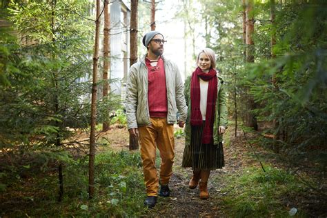 아름다운 가을 오후에 숲을 걷는 동안 손을 잡고 있는 세련된 백인 커플 카메라를 보고 있는 예쁜 여자 사진 Unsplash의 가을 이미지