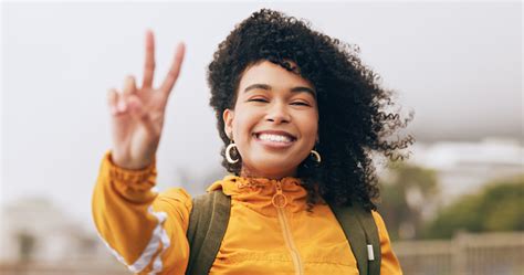 행복하고 젊은 흑인 여성과 평화의 손 기호는 여행과 모험이 있는 야외에서 초상화에 미소를 짓고 있습니다 도시 마을의 젊음 Z세대 도시 소녀 자유와 당일 여행으로 바람이 부는