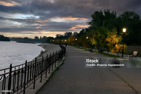 해질녘에 등불이 있는 보행자 도로가 있는 흐르는 강의 제방 아름다운 일몰 강에 대한 스톡 사진 및 기타 이미지 강 관광 구름 Istock