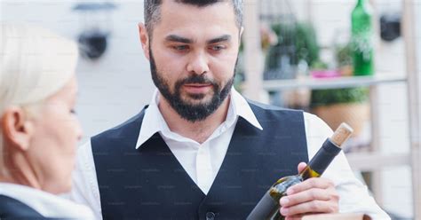 둘 다 지하실에서 일하는 동안 병에 담긴 새로운 종류의 와인의 특성을 제공하는 젊은 수염 바텐더 사진 Unsplash의 식당 이미지