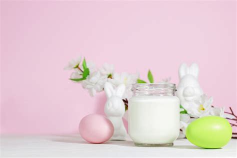 유기농 프로바이오틱 밀크 케피어 음료 또는 요구르트는 유리 용기에 색깔의 부활절 달걀 토끼와 분홍색 배경에 부활절 개념 프로바이오틱스와 함께 차가운 발효 우유 음료 0명에