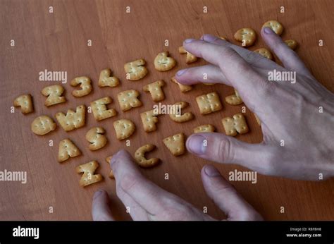 Mens Fingers Typing On The Keyboard Which Is Composed Of Salty Cracker In The Form Of Letters