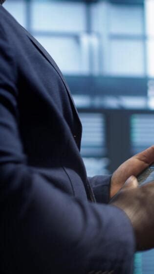 Vertical Technician Walking In Server Room Doing Checkup Inputting Data On Tablet Of Needed