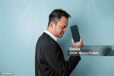검은 양복을 입은 젊은 아시아 사업가는 진지한 느낌으로 스마트 폰을 들고 화면에 복사 공간을 보여줍니다 20 29세에 대한 스톡 사진 및 기타 이미지 Istock