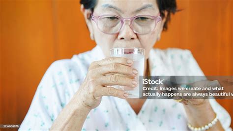 알약과 물 한 잔을 들고 약을 복용 준비를하는 노인 여성 집중하고 침착한 표정 건강관리와 의술에 대한 스톡 사진 및 기타 이미지 건강관리와 의술 건강한 생활방식 노인