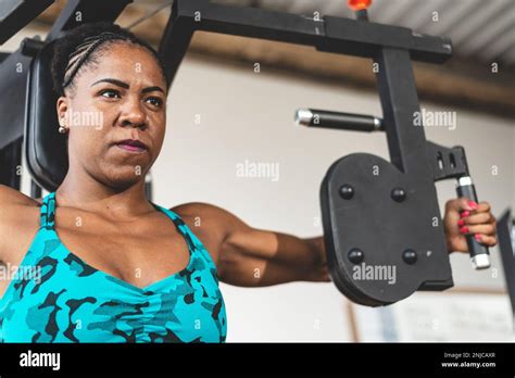 Woman Sitting On Machine Doing Arm Exercises Fitness In The Studio
