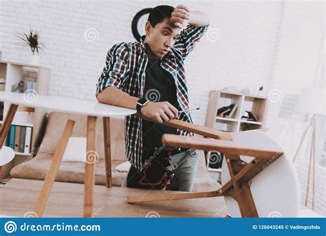 Young Man Assembling Coffee Table And Stools Stock Image Image Of Equipment Installing