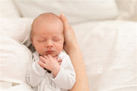 An Unrecognizable Mother Holding Her Newborn Son At Home Close Up