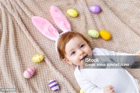 토끼 귀와 페인트 달걀을 가진 귀여운 작은 아기가 베이지색 배경에 누워 미소 부활절 개념 6 11 개월에 대한 스톡 사진 및 기타 이미지 6 11 개월 공휴일 귀