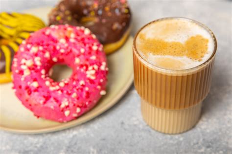 식탁에 컵과 도넛이 있는 현대적인 커피 머신 커피 하우스 주방에 컵이 있는 현대적인 에스프레소 커피 머신 향기로운 뜨거운 음료의