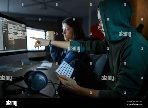 male and female hackers works on computers in darknet dangerous