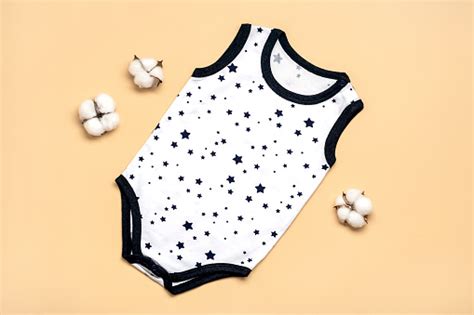 신생아를위한 별이있는 아름다운 흰 옷 베이지 색 배경에 고립 된 면화 복사 공간 어린 시절 모성 패션 섬유 및 신생아의 개념 탑 뷰 플랫 누워 0명에 대한 스톡 사진 및