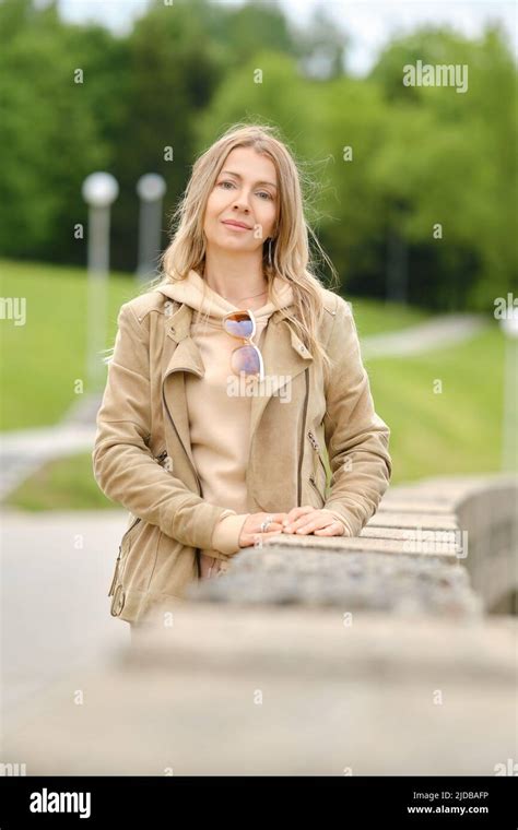 Cute Middle Aged Woman With A Wistful Look Standing By The River In