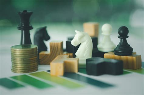 동전과 나무 퍼즐 블록의 더미와 체스그래프에 배치 텍스트 또는 디자인에 대한 복사 공간을 사용하여 백그라운드 비즈니스 개념 및 전략 개념으로 사용하십시오 체스에 대한 스톡