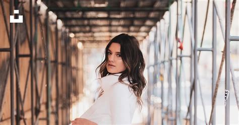 흰색 긴 소매 셔츠와 흰색 바지를 입은 여자가 복도에 서 있다 사진 Unsplash의 무료 갈색 이미지