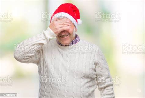 잘생긴 수석 사람 손으로 덮고 눈 깜짝 하는 얼굴에 웃 고 웃 고 고립 된 배경 위에 크리스마스 모자를 쓰고 눈 먼 개념입니다 가리기에 대한 스톡 사진 및 기타 이미지