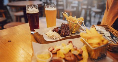 칩 감자 튀김 나무 보드에 소스를 곁들인 스테이크를 곁들인 맛있는 훈제 소시지 거리 패스트 푸드 축제 개념입니다 구운 고기와 차가운 맥주 음료 세련된 서비스 사진