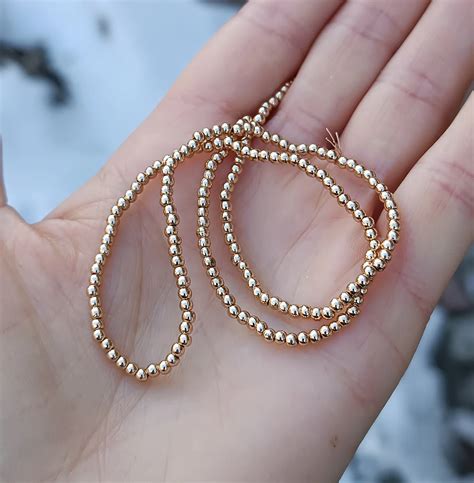 НАТУРАЛЬНЕ КАМІННЯ ФУРНІТУРА Гематит з покриттям куля 2 2 мм колір золото Довжина низки 38 см