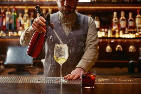 Bartender Preparing Cool Cocktail Standing In Spray Of Flying Liquid