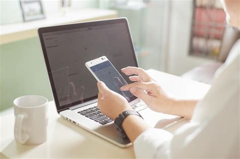 premium photo businessman hand using smart phone with laptopclose up seleted focus