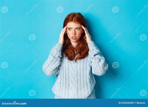 Young Tensed Redhead College Girl Trying To Think Rubbing Temples And