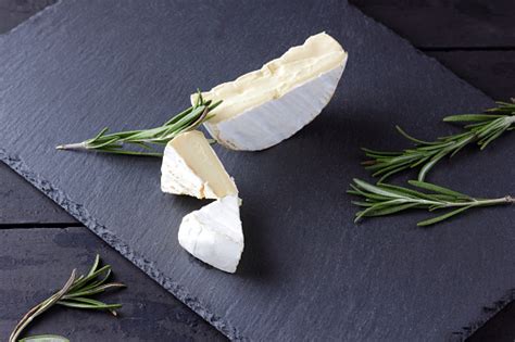 카망베르 고 검은 돌 보드에 로즈 메리입니다 검은 배경에 흰색 형 소프트 치즈입니다 슬라이스 치즈와 로즈마리 가지 슬레이트 보드에 0명에 대한 스톡 사진 및 기타 이미지