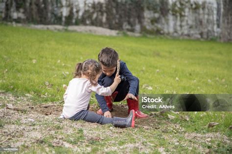 소년과 소녀는 자연을 탐험하면서 함께 놀고 더러워지는 것을 두려워하지 않고 땅에 앉아 재미있게 놀고 있습니다 행복한 어린 시절 우정 공유 및 학습 개념 2 3 살에 대한