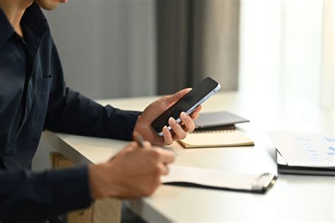 스마트폰을 사용하고 종이에 메모를 하는 성인 사업가 사람 기술 및 커뮤니케이션 30 34세에 대한 스톡 사진 및 기타 이미지 30 34세 경영자 계획 Istock