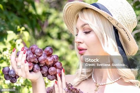 그녀의 손에 포도 한 다발을 들고있는 모자를 쓴 젊은 금발 여자의 사진 야외 레크리에이션 여름 피크닉 20 24세에 대한 스톡 사진 및 기타 이미지 Istock