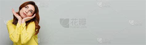 高兴的女人手拉手靠近脸抬头看灰色的横幅