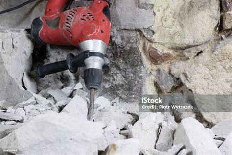 벽 철거 전기 해머 헬멧 및 청력 보호 잔해에 누워 오래 된 벽돌 그리고 리 모델링된 건물 벽입니다 오래 된 벽의 배경에 툴 툴 건설 기계류에 대한 스톡 사진 및 기타