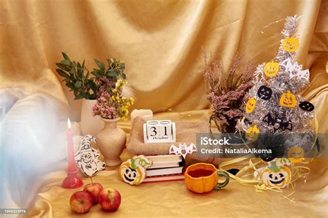 트렌디 한 할로윈 나무와 홈 파티 분위기 촛불 오렌지 머그잔 마른 꽃 호박과 유령 모양의 수제 쿠키와 함께 책과 달력으로 아늑한