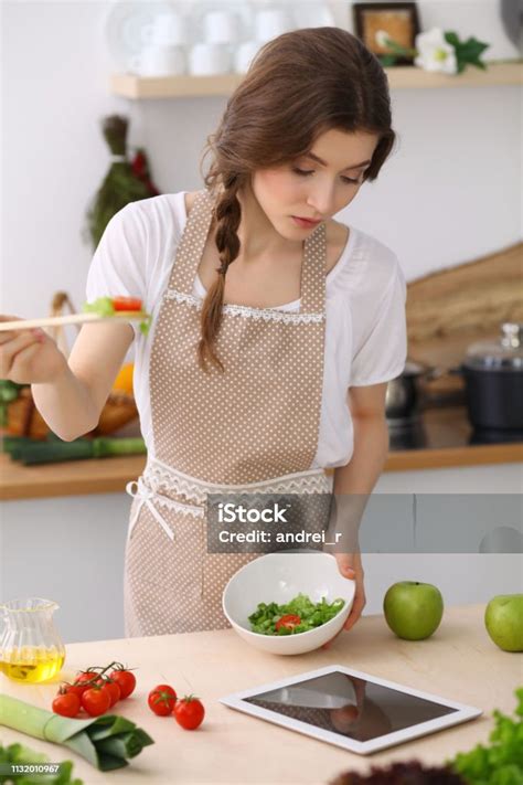 젊은 갈색 머리 여자 부엌에서 요리 그녀의 손에 나무 숟가락을 들고 주부 음식 및 건강 개념입니다 가정 생활에 대한 스톡 사진 및 기타 이미지 Istock