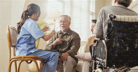 행복 쾌활한 노인 여성과 남성이 여성 간병인과 이야기하는 간호사 의사가 거실에서 건강 검진을 받고 있고 요양원의 거실에 앉아 있는 노인 부부와 간병인 사진