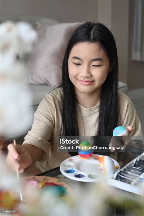 거실에 앉아있는 귀여운 소녀는 부활절 축제를 위해 계란에 그림을 그리는 것을 즐깁니다 10 11세에 대한 스톡 사진 및 기타 이미지 10 11세 가정 생활 가정의 방