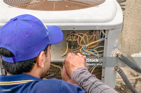 전문 전기 기술자는 건물의 지붕 상단에 있는 공기 조화 기의 무거운 단위를 고정 하 고 파란색 유니폼과 머리 캡을 착용 Stem 주제에 대한 스톡 사진 및 기타 이미지