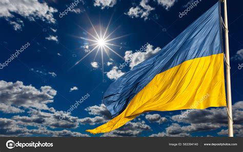 На блакитному небі летить великий національний прапор України Великий жовтий синій український