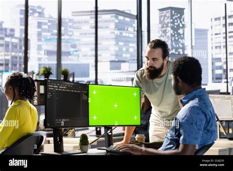 Programmer Doing Software Debugging On Green Screen Pc Asking For Help From Coworker Checking