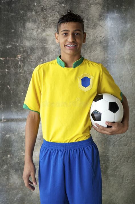 Smiling Young Brazilian Soccer Player In Uniform Holding Football Stock