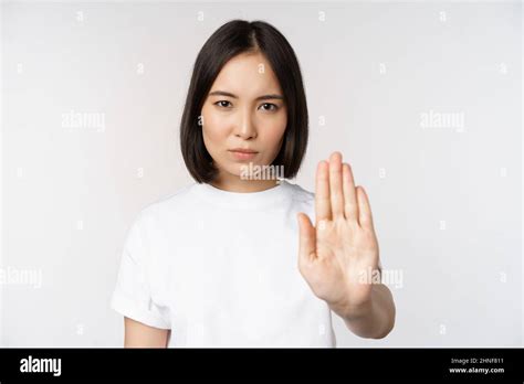 Image Of Asian Girl Showing Stop Prohibit Smth Extend One Arm To Show Forbidding Taboo