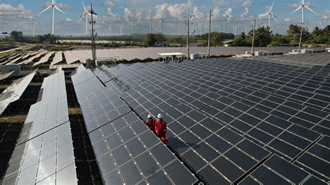 안전 장비 재생 가능 에너지 태양 전지판을 착용하고 지속 가능한 사업에서 검사를 위해 계획 태양 광 발전소에서 걷는 태양 광 분야의 두 명의 에너지 엔지니어 엔지니어링 지속