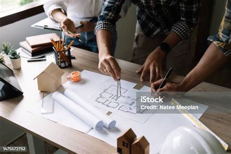 엔지니어와 건축가 사람들이 만나 작업하고 청사진에 손으로 그림을 그리고 동료와 브리핑을 합니다 엔지니어링 도구 및 건설 개념 그리기에 대한 스톡 사진 및 기타 이미지