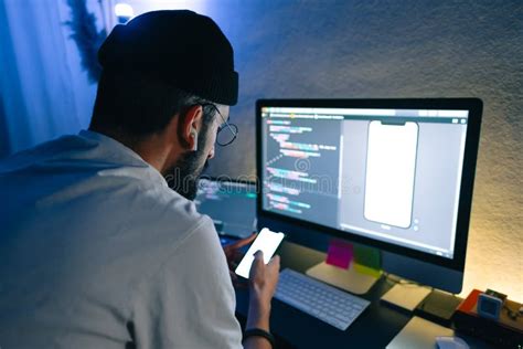 Young Man Mobile Developer Writes Program Code On A Computer And Check