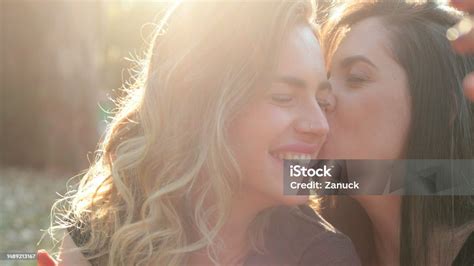 Girlfriends Posing For Selfie Friend Kissing Female Partner In Cheek