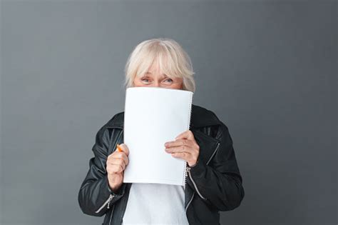 시니어 여성 가죽 재킷 스튜디오 서 서 회색 커버 얼굴에 노트북 찾고 카메라 장난 클로즈업 가죽에 대한 스톡 사진 및 기타 이미지 가죽 노인 락가수 Istock
