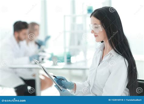 Close Up Woman Scientist Reading Notes In A Laboratory Journal Stock