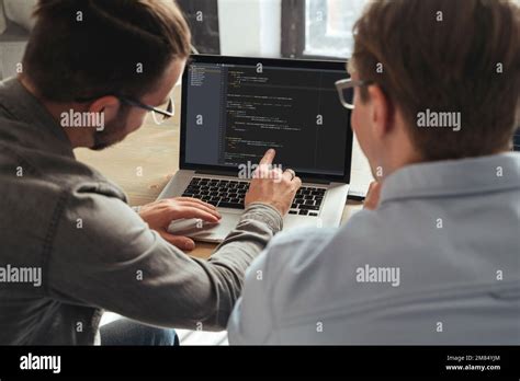 It Specialist Giving Personal Programming Lesson To Man Over Shoulder